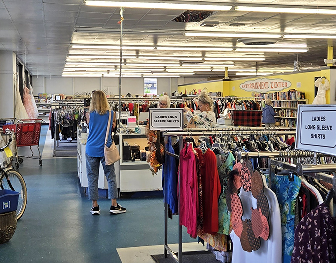 The women's clothing section: meticulously organized chaos where "Ladies Long Sleeve Shirts" isn't just a sign—it's a treasure map to your next favorite blouse.