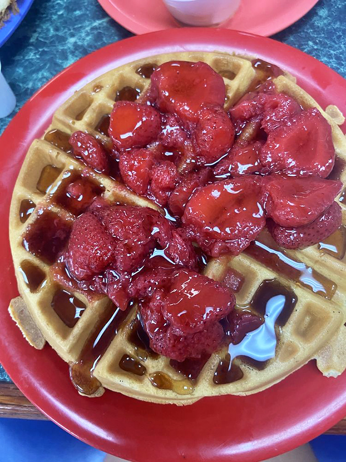 This Belgian waffle topped with strawberries isn't just breakfast—it's edible artwork that somehow tastes even better than it looks.