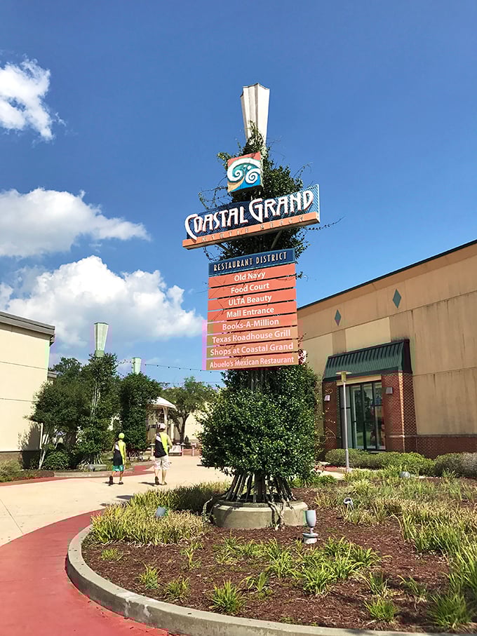 Coastal Grand's distinctive signage stands tall against Carolina blue skies, a beacon for shoppers seeking air-conditioned retail bliss.