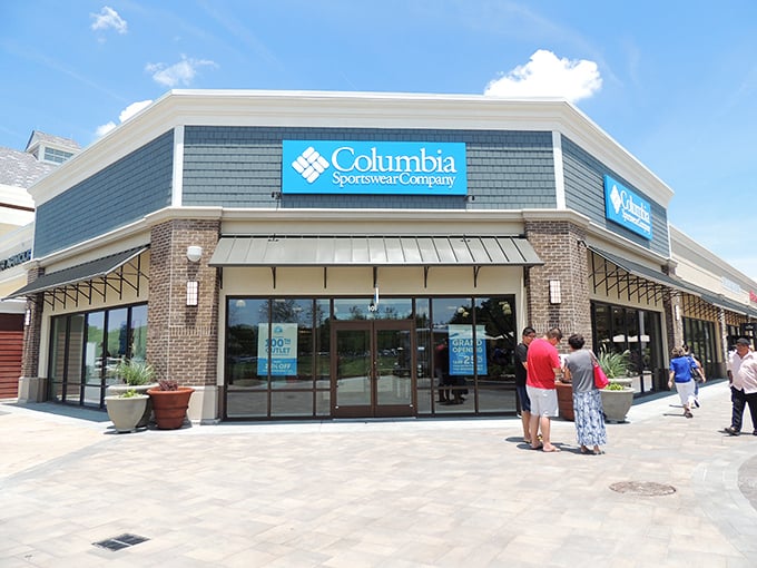 Columbia Sportswear's corner position makes it a beacon for outdoor enthusiasts seeking deals. The brick and stone façade adds a touch of permanence to fleeting fashion.