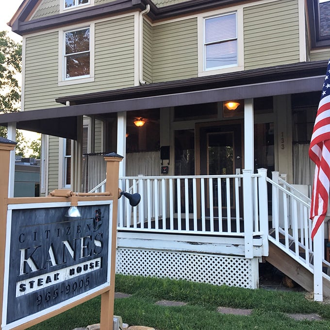 The white porch and American flag welcome you to Citizen Kane's – where steakhouse meets grandma's house in the best way.