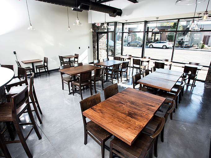 Clean lines and wooden tables create the perfect stage for the real performance – watching your pizza transform in the wood-fired oven.