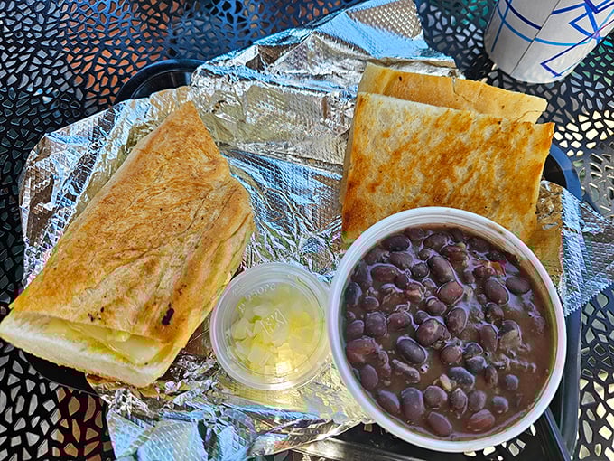 Black beans so rich they could buy beachfront property, paired with a sandwich pressed to crispy perfection—comfort food that speaks two languages fluently.