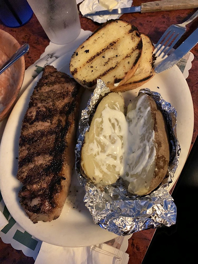 Nothing says "I deserve this" quite like a perfectly grilled steak alongside a foil-wrapped potato bursting with buttery goodness and a slice of Texas toast.