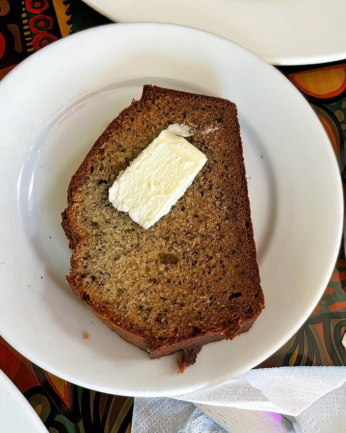 Banana bread so moist and flavorful it deserves its own tropical real estate listing. The pat of butter? Just showing off.
