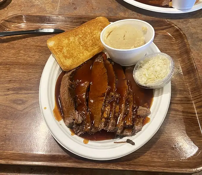 Brisket sliced so perfectly it could make a Texas pitmaster weep with joy, glistening with sauce that should be bottled and sold as cologne.