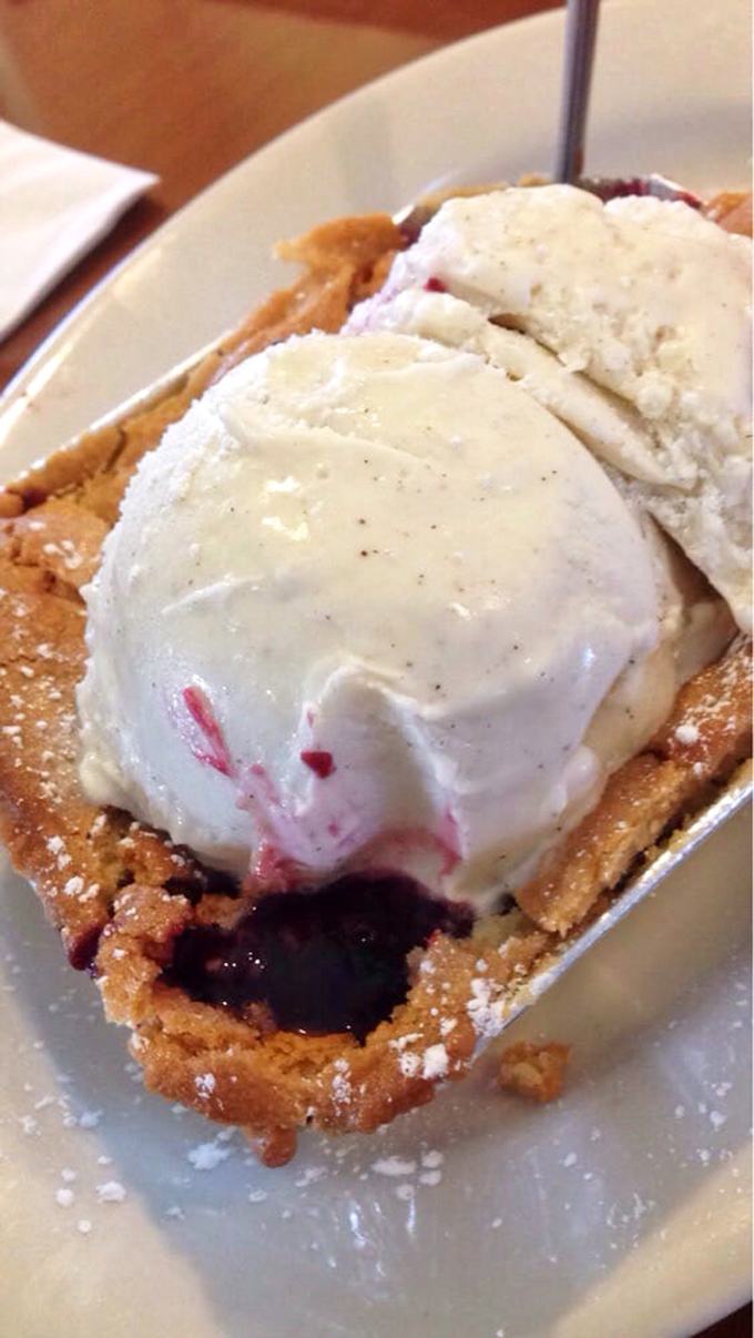 Dessert isn't an afterthought here—this berry cobbler with vanilla ice cream is the encore after a magnificent meat symphony.