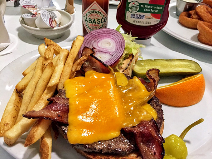 This isn't just a burger—it's an architectural marvel with bacon and cheese that requires both hands, several napkins, and absolutely no shame.