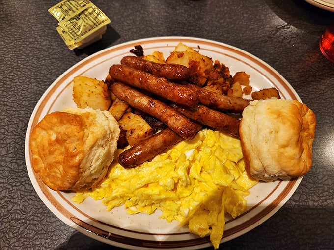 Breakfast architecture at its finest—golden biscuits, perfectly cooked sausage links, and eggs that practically wink at you from the plate.