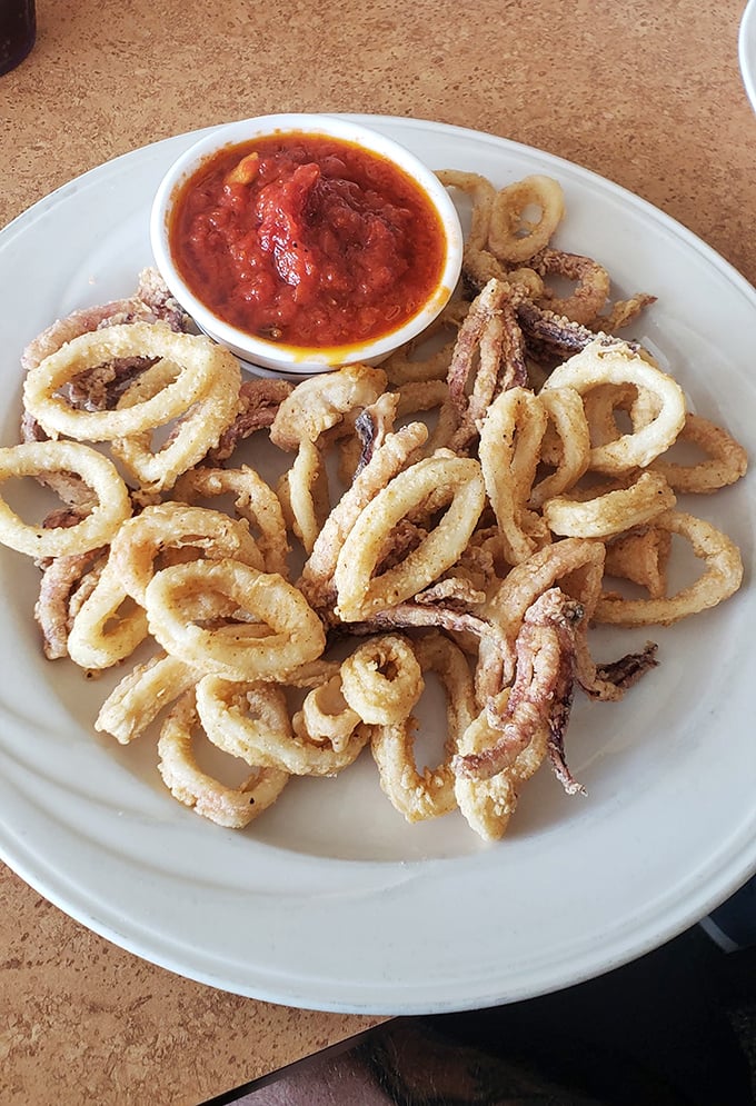 Calamari rings stacked like delicious golden halos, with marinara for dipping. Crispy, tender, and never rubbery—the seafood trifecta.
