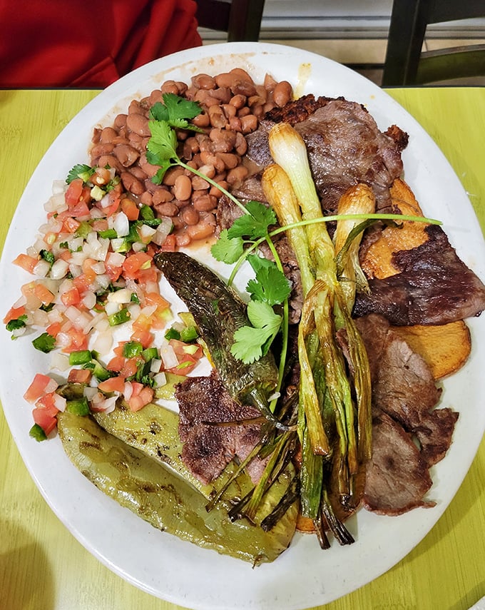 This isn't just steak – it's a carnivore's dream team. Grilled green onions, beans, pico de gallo, and that perfectly charred cactus paddle create a flavor symphony.