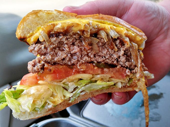 Cross-section of heaven. The perfect burger architecture reveals itself—juicy patty, melted cheese, fresh veggies, all in harmonious balance.