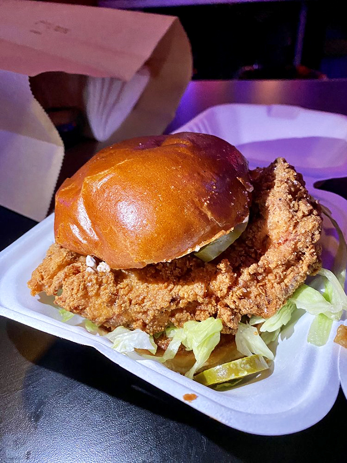 Fried chicken perfection: a golden-brown crust giving way to juicy meat, all nestled on a pillow-soft bun with crisp lettuce.