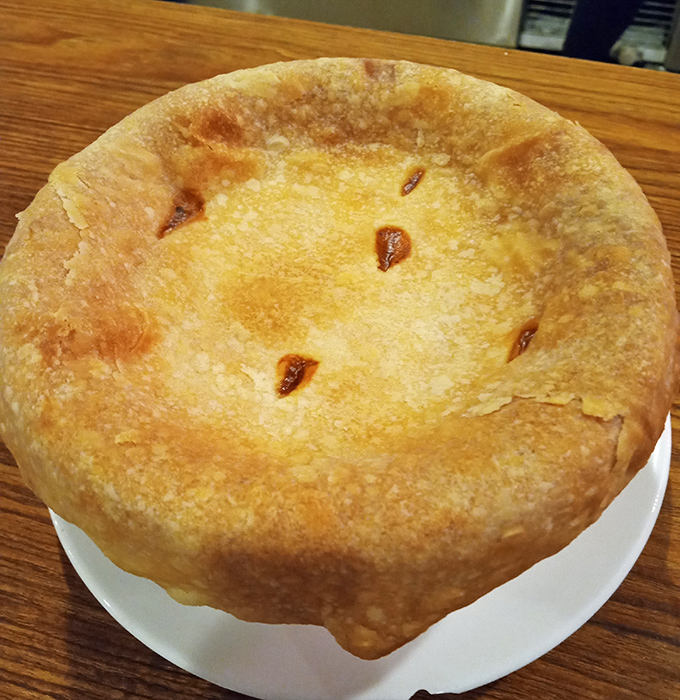 Behold the chicken pot pie—comfort food architecture at its finest, with a golden dome sheltering a savory treasure of chicken and vegetables.