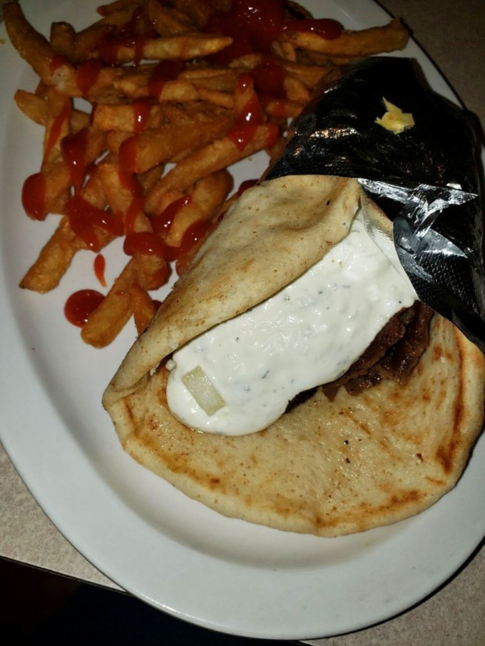 This gyro isn't just wrapped—it's embraced in warm pita with a sauce so good you'll be plotting your return before the last bite.