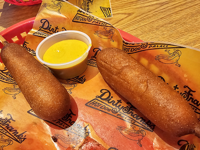 Corn dogs elevated to royalty status—crispy, golden sheaths protecting juicy dogs within, served with liquid sunshine for dipping.