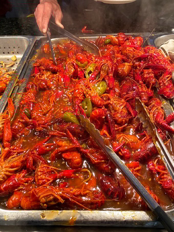 A sea of crimson crawfish swimming in savory sauce – proof that sometimes the messiest foods are the most satisfying. Keep those napkins handy!