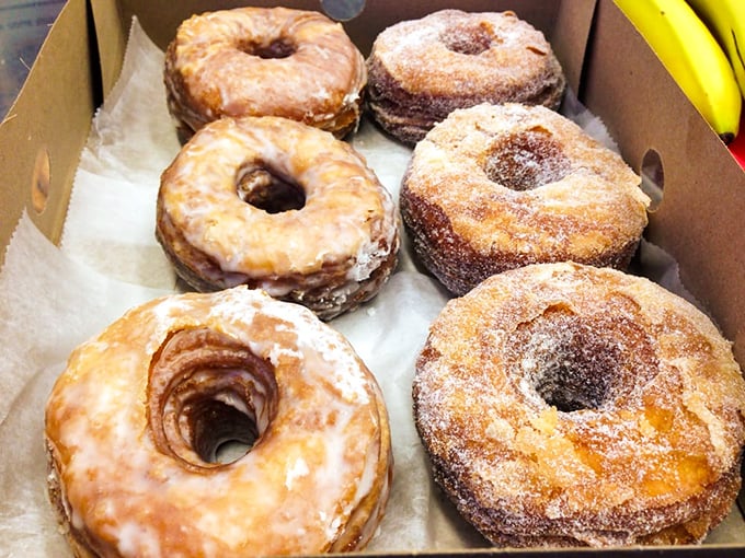 Six perfect specimens of donut artistry—three glazed, three sugar-dusted—nestled in their box like precious jewels in a bakery treasure chest.