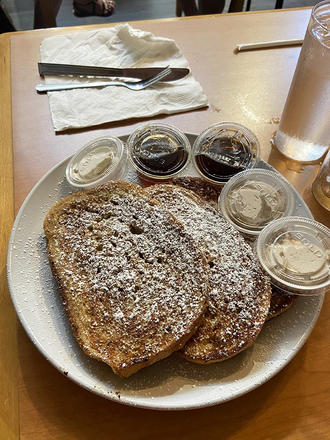 Heart-shaped French toast dusted with powdered sugar and surrounded by tiny cups of sweet possibilities—breakfast's answer to a candy store.