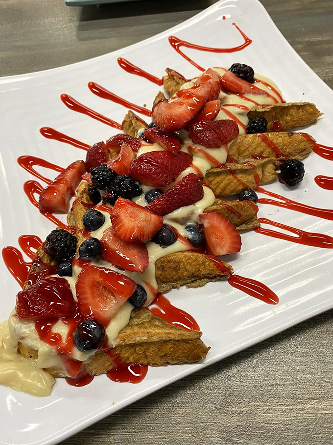 French toast elevated to art form—custard-soaked bread adorned with berries and cream drizzles that would make even breakfast skeptics weak at the knees.