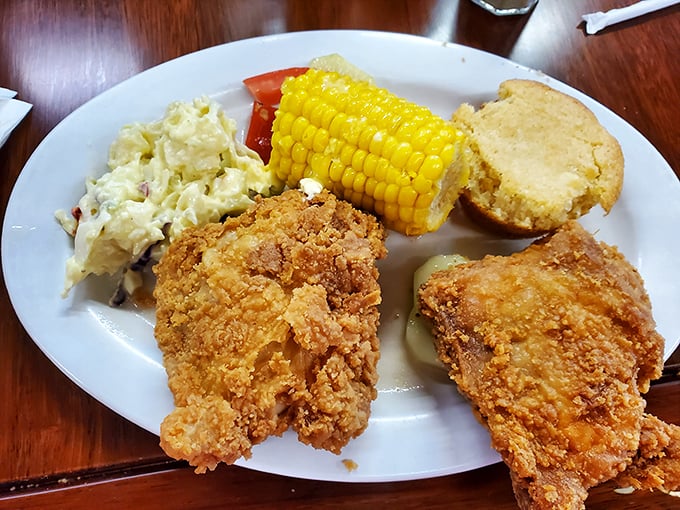 Southern harmony on a plate: crispy fried chicken, creamy potato salad, sweet corn, and cornbread—a quartet that sings in perfect culinary unison.