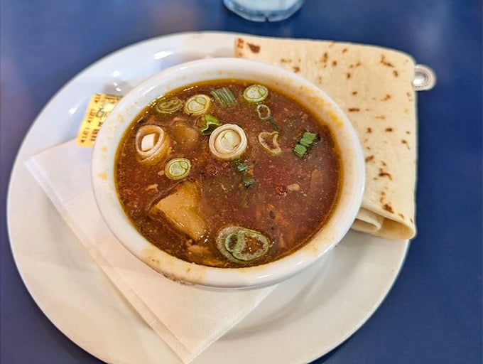 Green Chile Stew that looks like it could cure whatever ails you – served with a tortilla that's practically begging to dive into that flavorful broth.