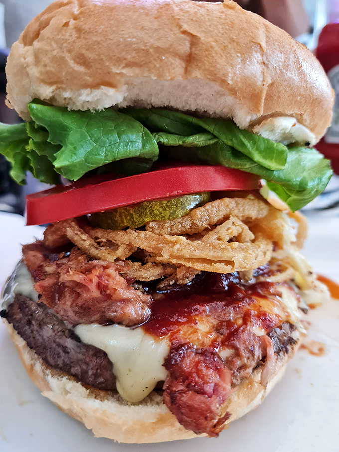 This isn't just a burger; it's a skyscraper of flavor with crispy onions, melted cheese, and enough layers to require an engineering degree to eat.