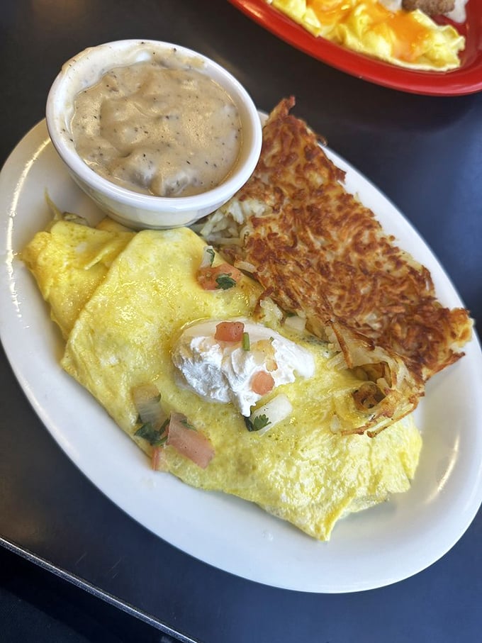 Golden hash browns that crackle with each bite sit alongside an omelet stuffed with enough fillings to qualify as a complete food group. Comfort food that demands a nap afterward.