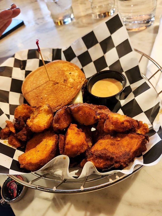 Comfort food diplomacy in action—this basket of golden-brown delights, served with a creamy dipping sauce, exemplifies the diner's commitment to happiness through carbohydrates.