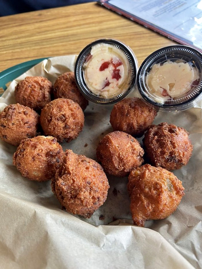 These golden-brown hushpuppies aren't just side dishes—they're little spheres of Southern comfort, served with dipping sauces that elevate the humble cornmeal to art form.