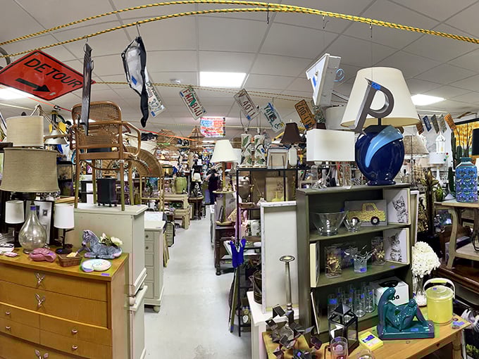Lampshades and furniture create little vignettes of possibility. Each aisle tells a different story—mid-century modern on the left, grandma's attic on the right