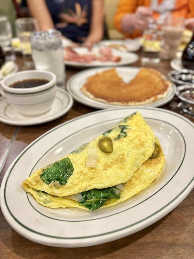 This isn't just an omelet; it's a masterpiece of folded eggs embracing spinach and jalapeños in a morning dance.