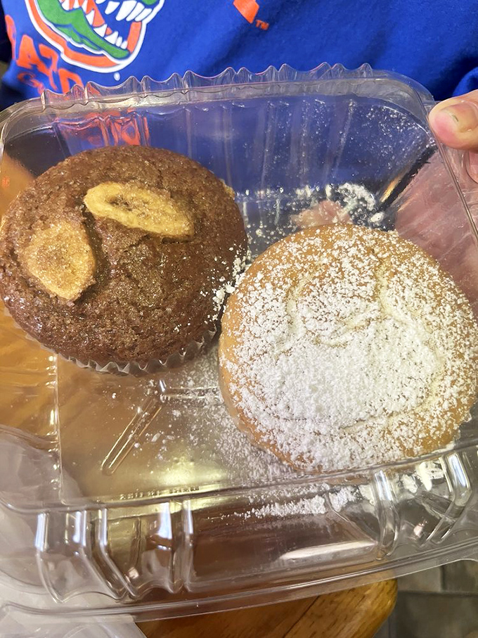 These muffins aren't just baked goods – they're edible souvenirs. One banana-topped beauty and one powdered masterpiece ready for their close-up.