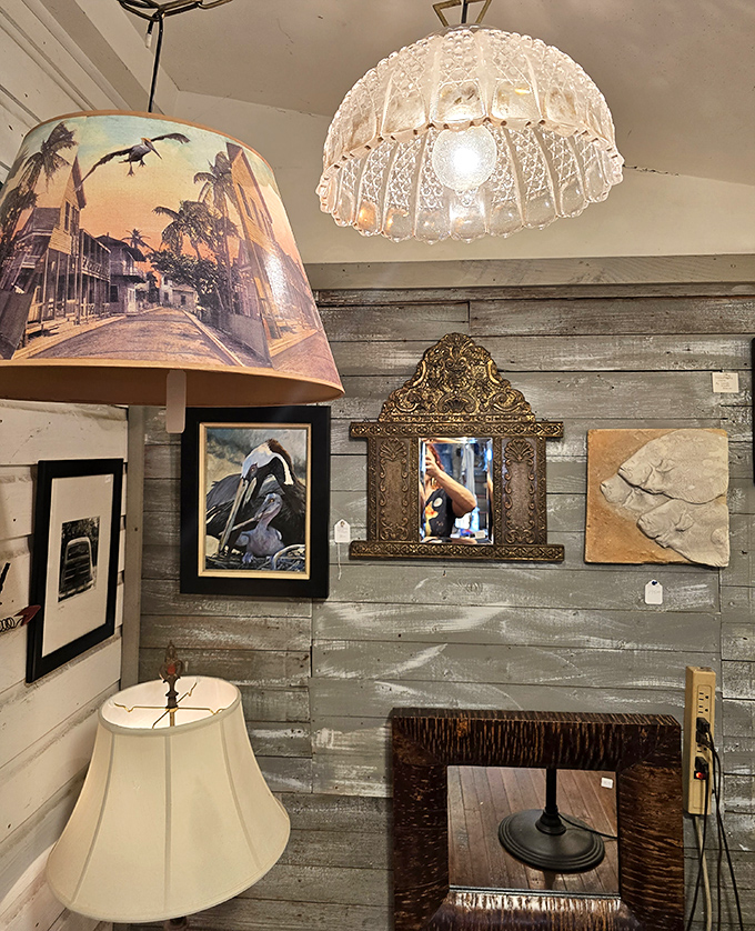 Where lighting becomes art – a vintage Key West street scene lampshade casts warm glow alongside crystal fixtures that once illuminated who-knows-what fascinating gatherings.