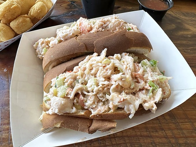This isn't just a sandwich; it's a seafood celebration. Chunky lobster salad spilling from a soft roll—summer in edible form.