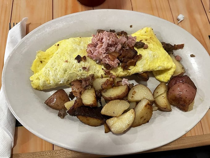 This isn't just an omelet—it's a protein festival wrapped in egg. Those potatoes on the side are the unsung heroes of the plate.