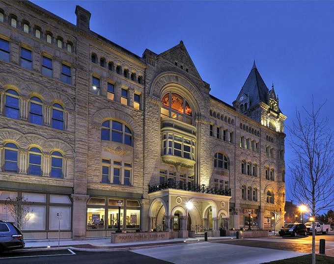 The Piqua Public Library glows at dusk, transforming from impressive stonework to magical beacon of knowledge and community.