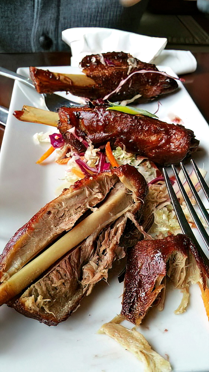 These aren't wings from any ordinary bird—glazed pork "wings" offer a primal pleasure, the meat surrendering from the bone with just the gentlest tug.