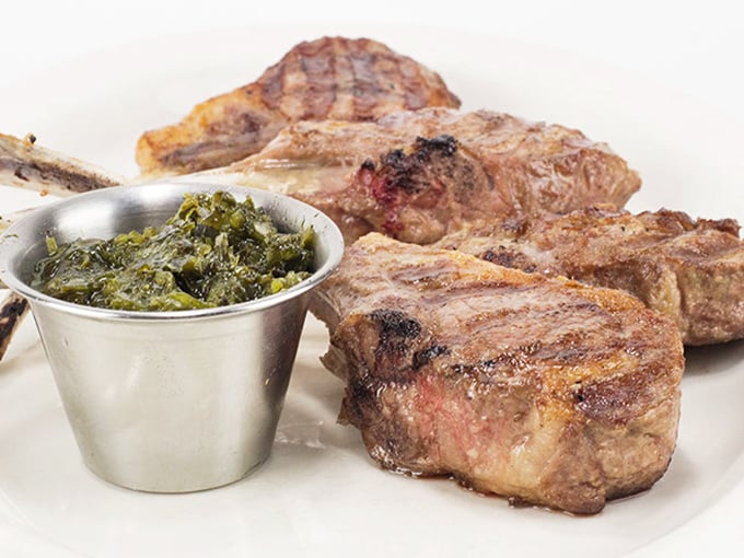 Lamb chops that don't just satisfy hunger—they restore your faith in simple pleasures. That side of greens? Just enough virtue to justify indulgence.