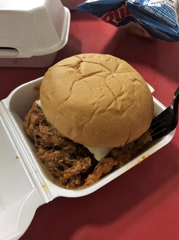 The pulled pork sandwich doesn't need fancy presentation—when flavor speaks this loudly, white styrofoam becomes fine china.