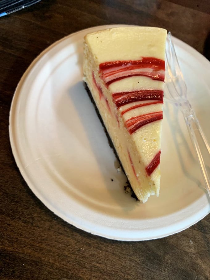 Those ruby-red ribbons of raspberry aren't just for show—they're flavor highways cutting through creamy cheesecake valleys. Visual deliciousness at its finest.