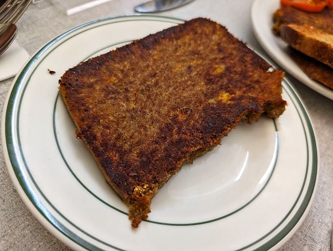 Perfectly seared and caramelized, this slice of scrapple is the diner's unsung hero—crispy exterior giving way to a savory interior that defies description.