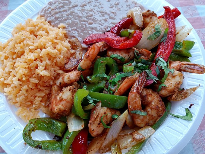 Sizzling shrimp fajitas flanked by Spanish rice and refried beans—a holy trinity of flavors that would make even a food critic weep with joy.