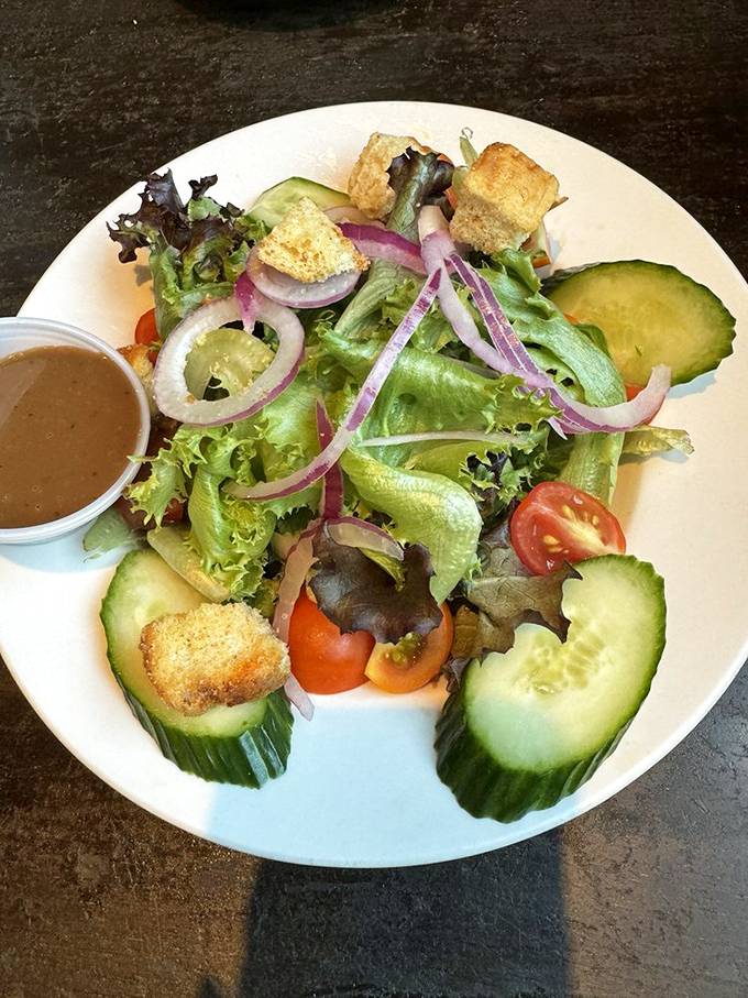 A house salad that defies the "rabbit food" stereotype – crisp, colorful, and composed with enough care to make you temporarily forget about the fish and chips.