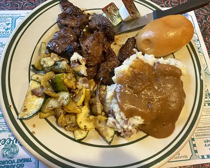 Steak tips with all the fixings—when the gravy pool meets the mashed potato mountain, magical things happen on this plate.