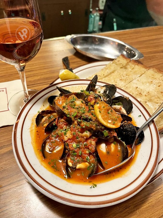 These mussels aren't just swimming in sauce—they're doing the backstroke in a pool of flavor that demands bread for sopping duties.