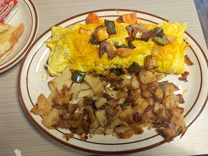 The Western omelet—where vegetables pretend they're attending a cheese party. Those home fries are the crispy supporting actors who steal the scene.
