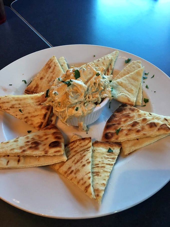 Triangles of warm pita surround a creamy dip like devoted fans at a concert—simple geometry never tasted so good.
