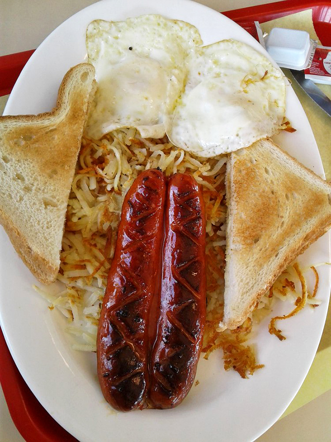Two linguica sausages standing proud on a bed of golden hash browns with eggs and toast. This isn't breakfast—it's morning therapy.