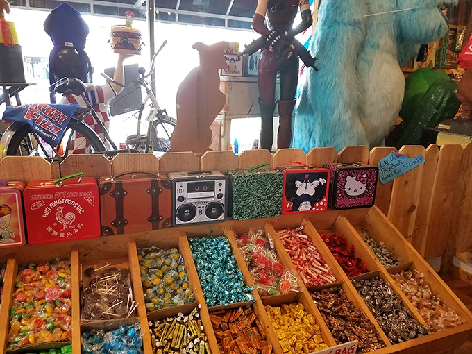 Wooden compartments organize a treasure trove of individually wrapped candies, while vintage lunch boxes stand guard above—silent sentinels of childhood memories.